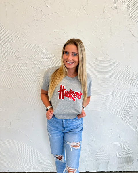 RED METALLIC / WHITE HUSKERS SCRIPT - LIGHT GREY CROP TEE – H.FLYNN